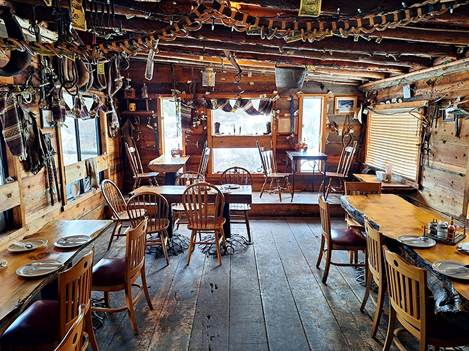 Rustic log cabin charm with cowboy hats and ranch tools adorning every surface&mdash;dining rooms don't get more authentically Western than this.