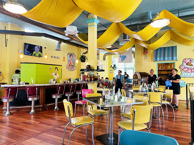 The dining room feels like breakfast's natural habitat&mdash;chrome, color, and cheerful chaos under yellow canopies that make every day feel like Saturday morning.