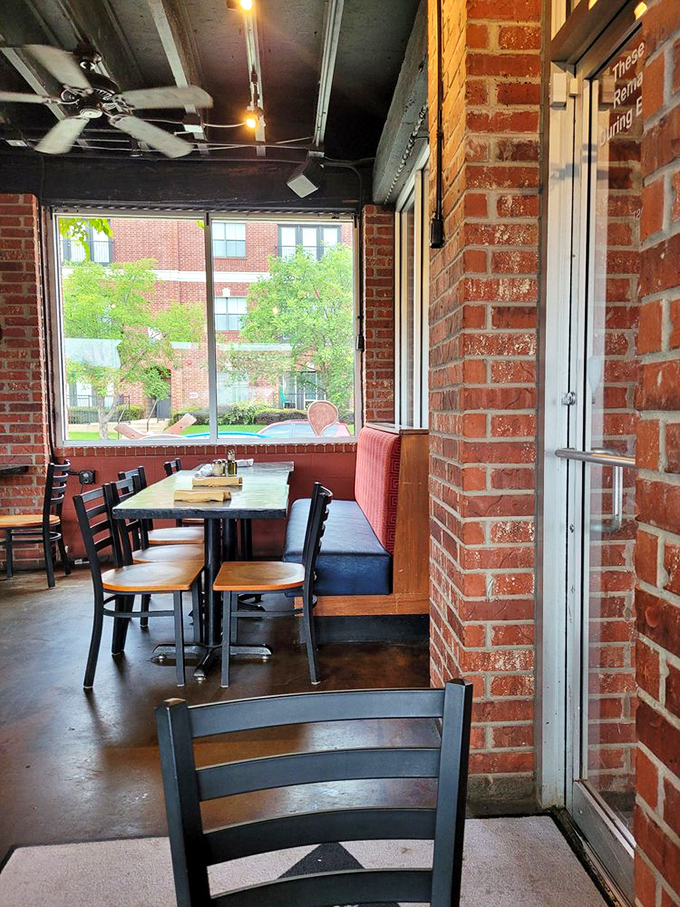 Sunlight streams through windows onto brick walls and wooden tables. This corner booth practically whispers, "Stay awhile, order another round."
