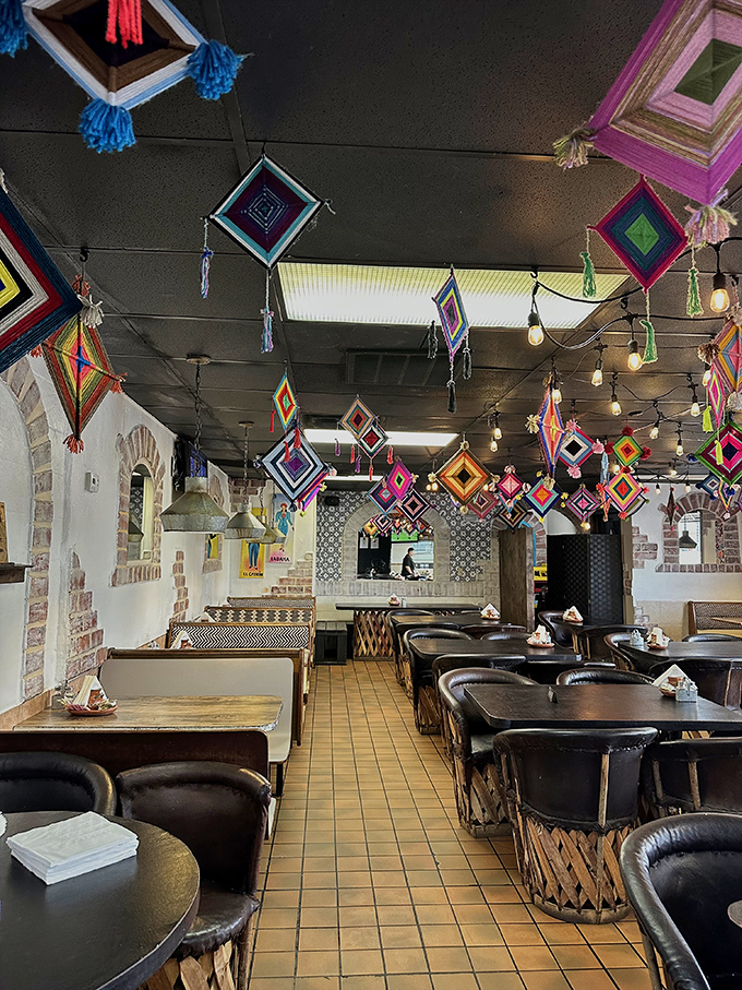 Vibrant Ojos de Dios (God's eyes) decorations dangle from the ceiling like colorful guardians watching over your dining experience.
