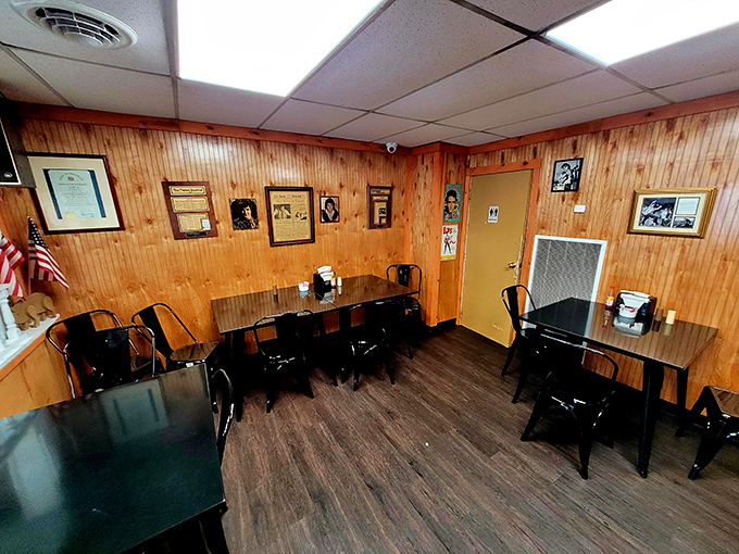 Simple black tables against wood-paneled walls&mdash;a dining room that says, "We put our energy into the food, not the furniture."