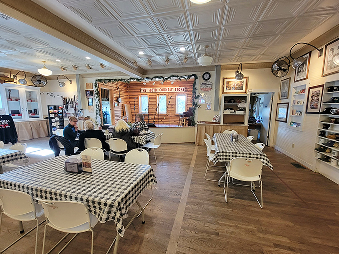 The dining area balances country charm with practicality&mdash;those black-and-white checked tablecloths aren't just decorative; they're the unofficial flag of comfort food territory.