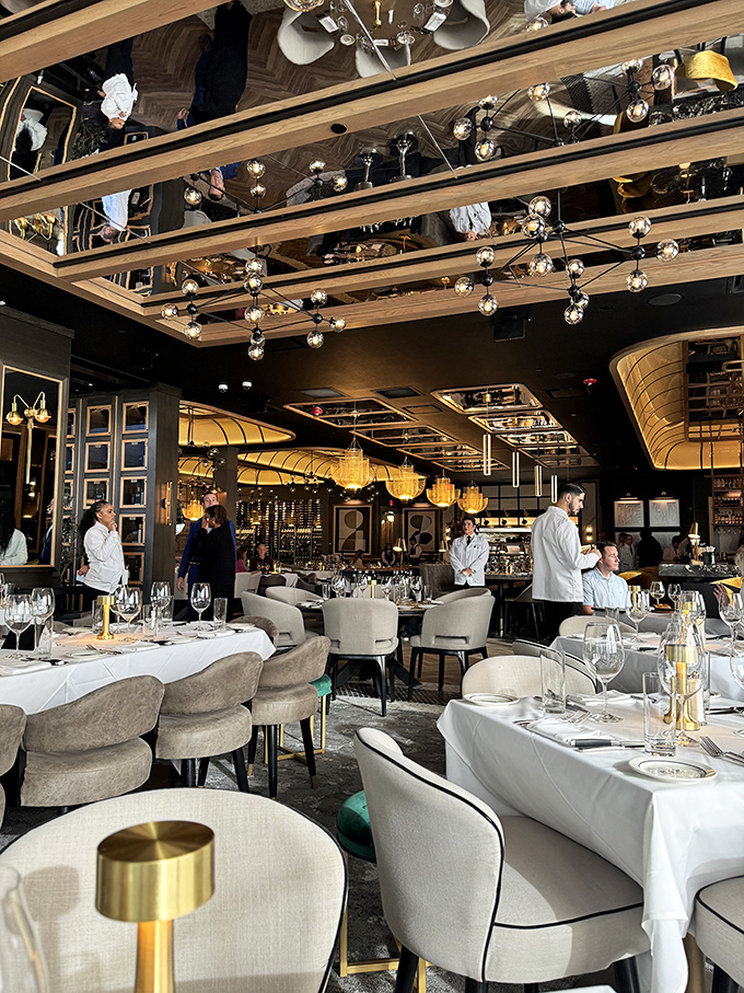 The dining room balances opulence with comfort, where mirrored ceilings reflect both the elegant space and your growing anticipation.