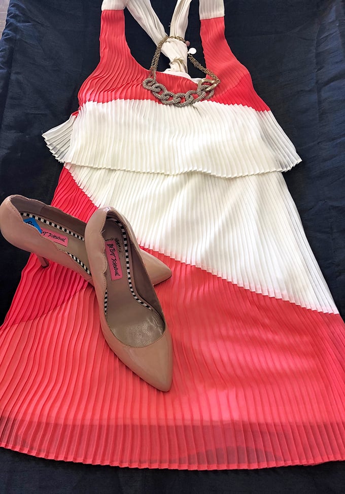 A coral and white pleated dress paired with nude heels&mdash;someone's special occasion outfit becomes your next great find.