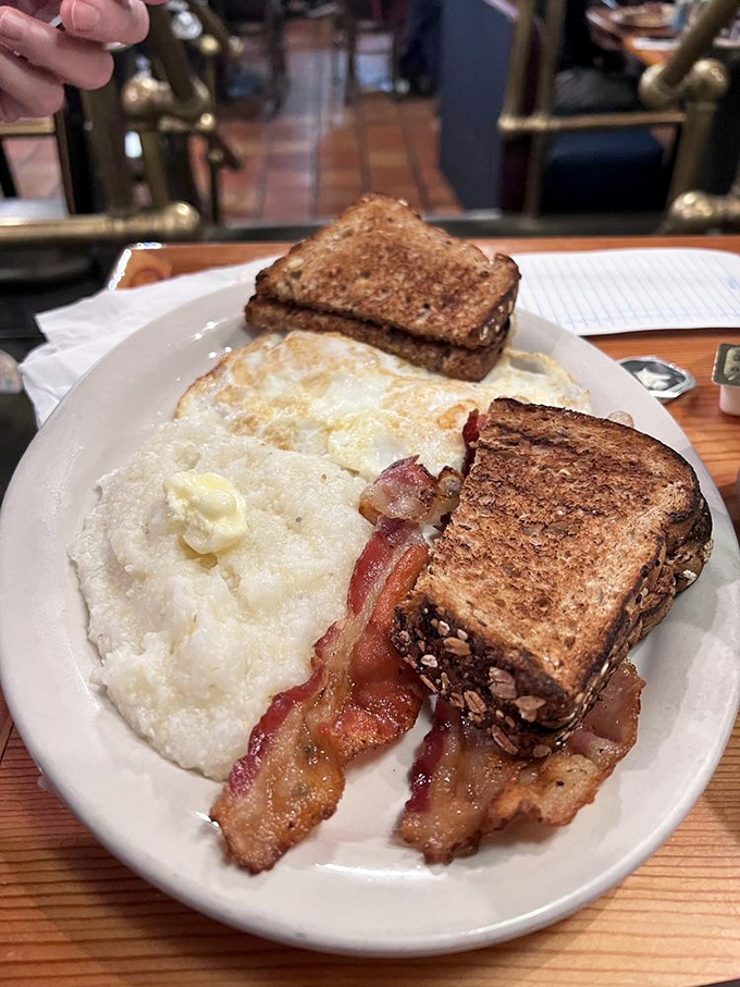 The breakfast trinity: perfectly crisp bacon, golden toast, and eggs that would make a chicken proud. Simple perfection needs no explanation.