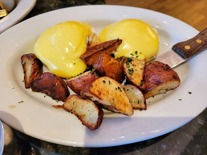 Eggs Benedict executed with military precision: perfectly poached eggs standing at attention under a hollandaise salute.