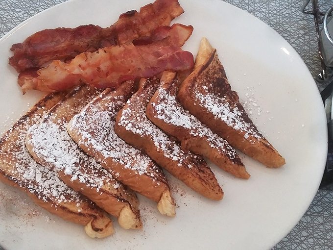 French toast dusted with powdered sugar alongside bacon that's achieved that magical balance between crisp and chewy&mdash;breakfast's perfect harmony.