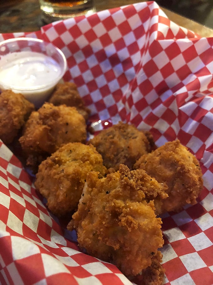 Golden-fried mushroom bites nestled in their checkered basket—these little flavor bombs disappear faster than your willpower ever could.