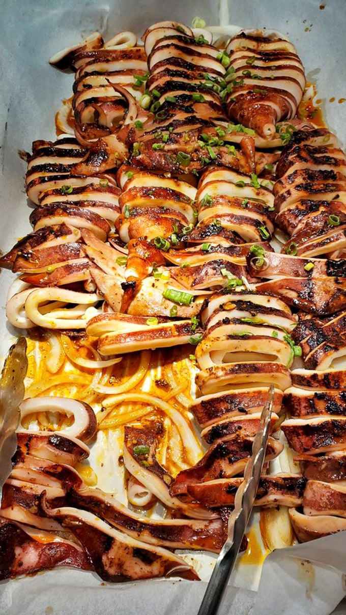 Grilled squid, lovingly crosshatched and glistening with savory sauce &ndash; proof that buffet food can transcend the steam table stereotype with proper technique.
