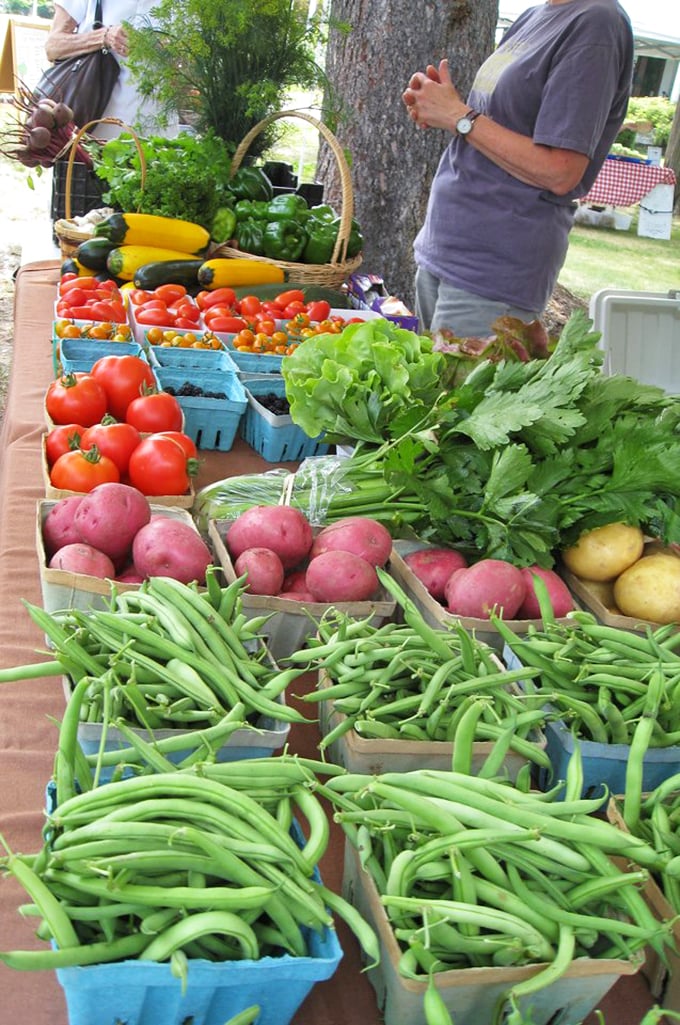 Farm-fresh bounty overflows at Wellsboro's local market, where vibrant green beans and ruby-red tomatoes showcase the region's agricultural riches.