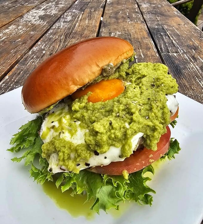 Avocado cascades over this burger like green lava, proving that sometimes the messiest foods are life's greatest pleasures.