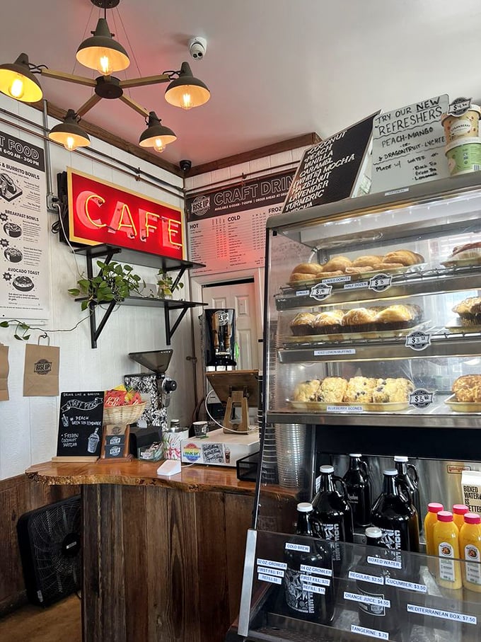 The "CAFE" sign glows like a beacon of hope above pastry cases filled with carbohydrate dreams and coffee possibilities.