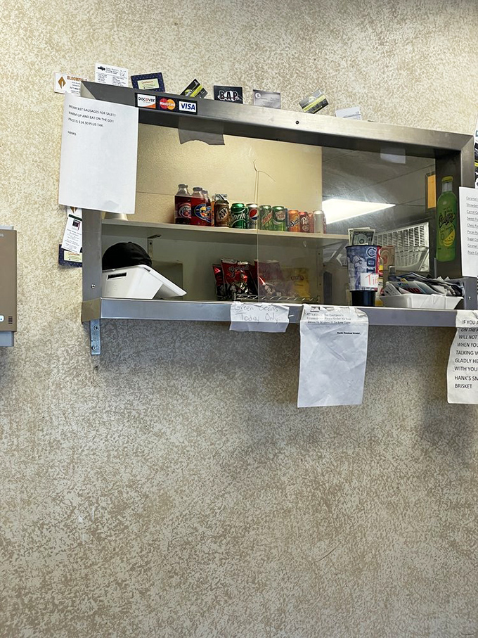 Business cards and credit card logos frame the ordering window&mdash;a collage of loyal customers who've found their barbecue home.