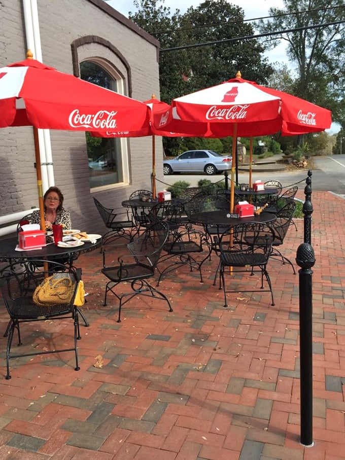 The outdoor seating area with classic Coca-Cola umbrellas&mdash;where pizza meets fresh air and somehow tastes even better under Georgia's blue skies.