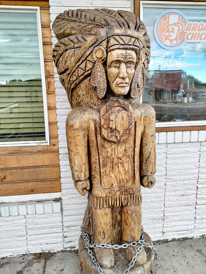 This wooden Native American statue guards the entrance like a sentinel of sustenance, weathered by years of Idaho seasons.