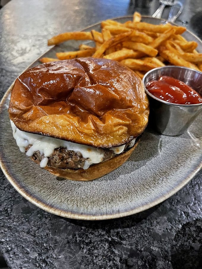 This isn't just a burger; it's a manifesto in bun form. Melted cheese cascading down a juicy patty with golden fries standing guard.