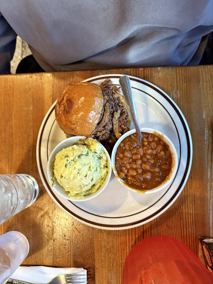The pulled pork sandwich&mdash;where tender strands of smoke-kissed meat find their soulmate in a soft bun, with beans standing by for moral support. 