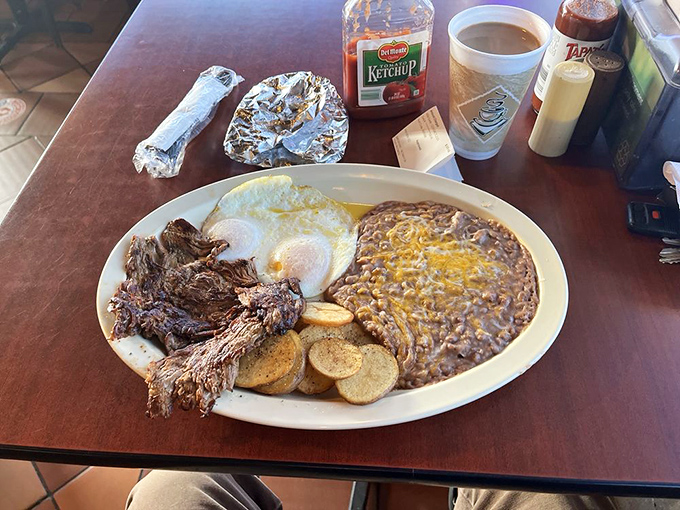 Breakfast of champions: tender shredded beef, perfectly fried eggs, and beans that have clearly been simmering since dawn. Morning fuel that'll keep you going until dinner.