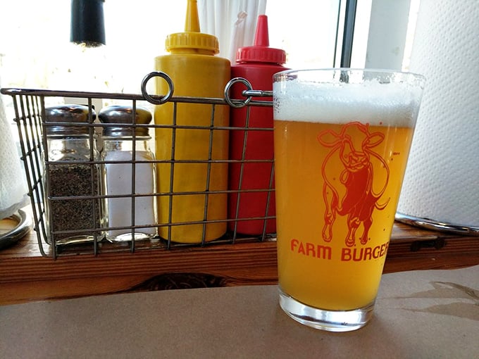 A golden pilsner in a Farm Burger glass, with condiments standing at attention nearby. Beer and burgers&mdash;a romance that never gets old.