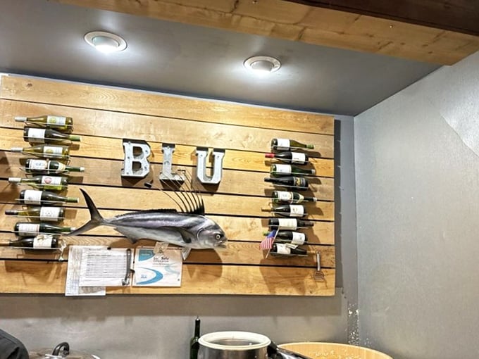 Wall Decor: Nothing says "trust our seafood" like mounting a giant fish on reclaimed wood with wine bottles standing guard on either side.
