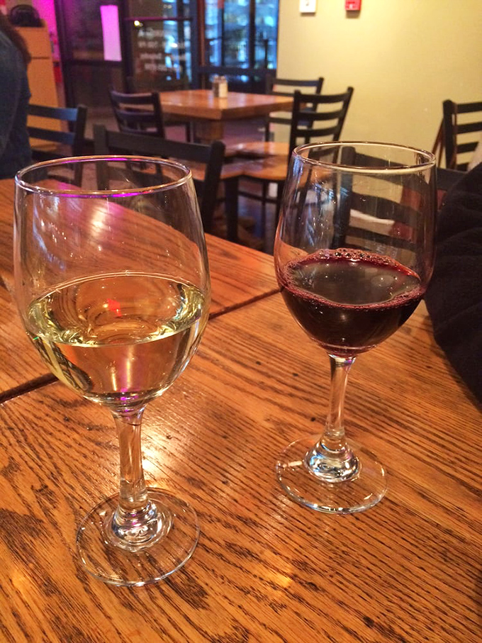 Wine glasses catching the warm glow of restaurant lighting&mdash;a still life painting you can drink. Red or white? The eternal question with no wrong answer.