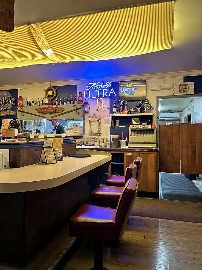 The bar area glows with neon beer signs and maritime charm. Where fishermen's tales get taller and seafood tastes better with each sip.
