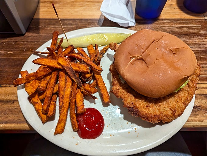 A perfectly crisp chicken sandwich with sweet potato fries that look like they were hand-cut by someone who truly understands comfort food.