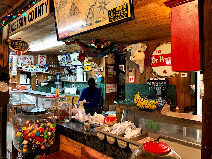Behind this counter, memories are made one scoop and sandwich at a time. The Henderson County sign above reminds you exactly where this magic happens.