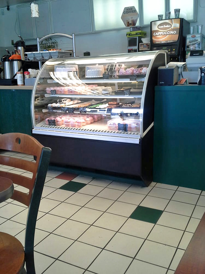 Behind this glass lies the daily parade of possibility—each tray a different neighborhood in the diverse metropolis of Donutville.