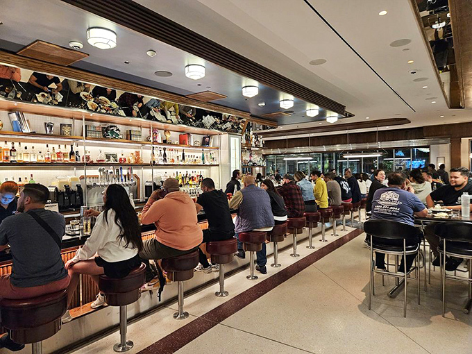 The bar area at peak hours looks like the United Nations of hunger, where strangers united by the universal language of "I need pancakes now" gather.