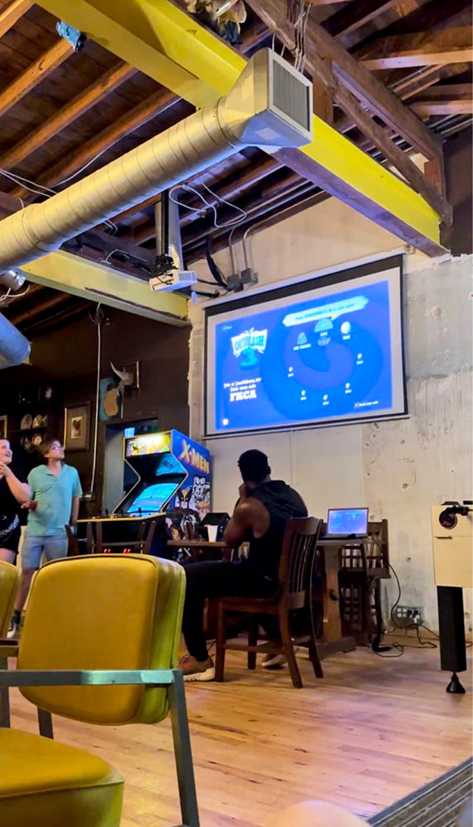 The wooden beams and exposed infrastructure create a comfortable industrial vibe where gamers gather to battle on-screen while bonding in real life.