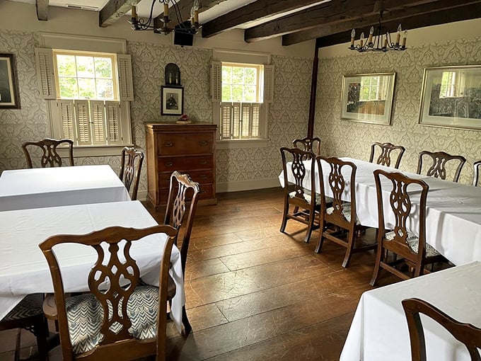 Elegant simplicity reigns in this dining room, where period-appropriate chairs and wallpaper transport you to a genteel era of unhurried conversation.