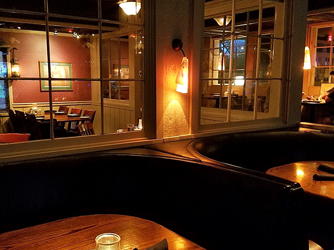 Cozy booths create intimate dining islands where conversations flow as smoothly as the wine. Notice the warm lighting that flatters everyone.