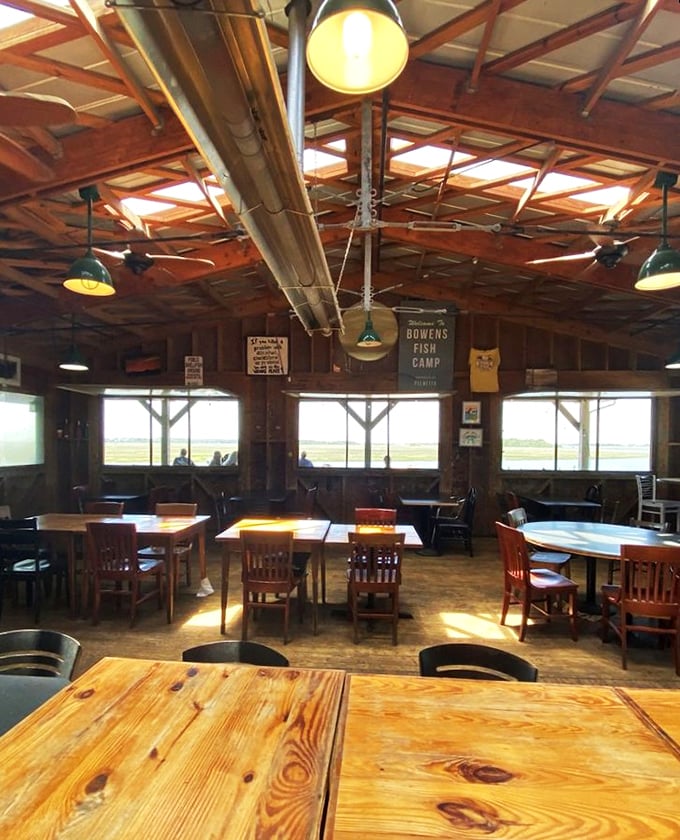 Sunlight streams through windows framing marsh views, turning simple wooden tables into front-row seats to coastal Carolina's daily show.