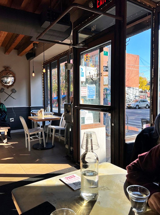 Sunlight streams through large windows, illuminating a corner spot where countless brunches and heart-to-hearts have unfolded over perfect plates.