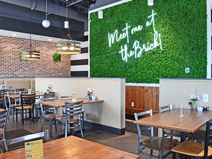 "Meet me at the Brick" glows against that signature green wall. The wooden tables practically whisper promises of plates that'll make you swoon.