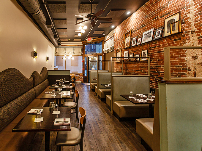 The dining room whispers "stay awhile" with its exposed brick, golden lighting, and booths that cradle you like a warm New England hug.