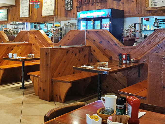 Wooden booths create intimate dining islands in a sea of breakfast aromas. These aren't just seats—they're front-row tickets to the breakfast show.