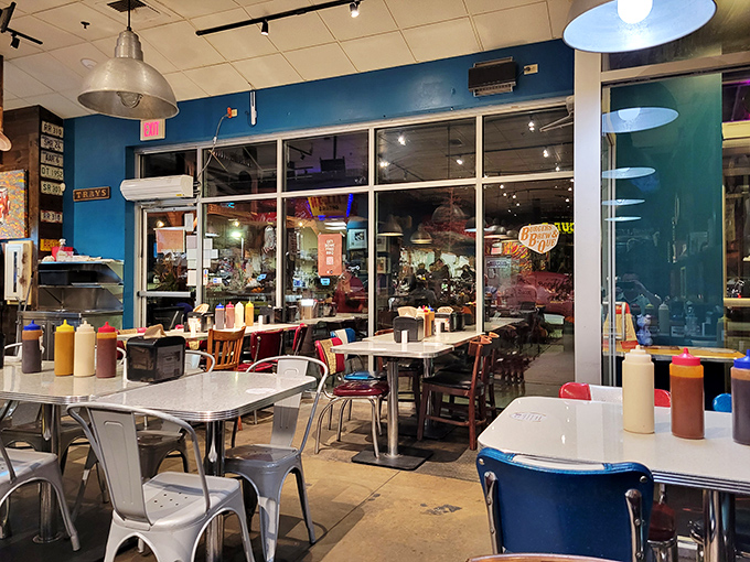 The blue walls and industrial lighting create a casual vibe where sauce bottles stand ready for duty like colorful soldiers.