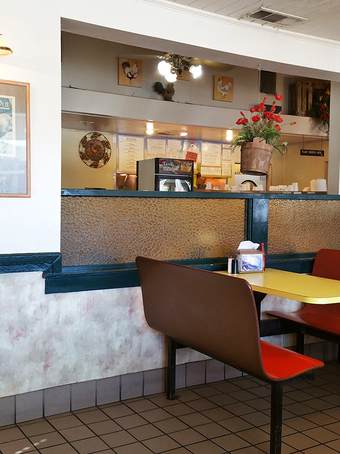The counter view reveals chicken-themed decor and fresh flowers. It's like Grandma's kitchen got a charming restaurant makeover.