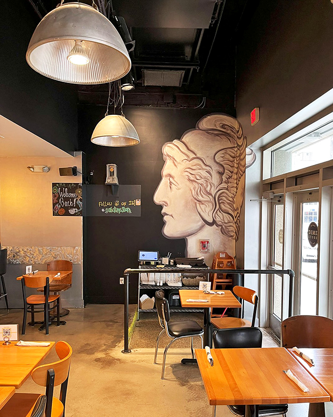The profile mural watches over diners like a benevolent deity of brunch, while industrial lighting creates the perfect ambiance for morning revelations over coffee.