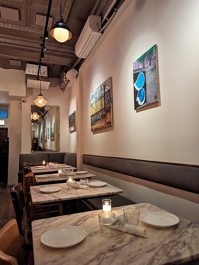 Marble tables, local art, and warm lighting create the kind of space where one cup of coffee easily turns into three.