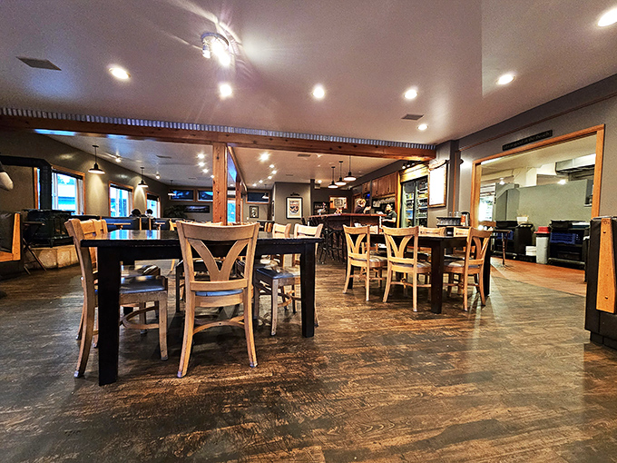 Empty tables waiting for the dinner rush &ndash; polished wood surfaces and warm lighting create an atmosphere that says "stay awhile."