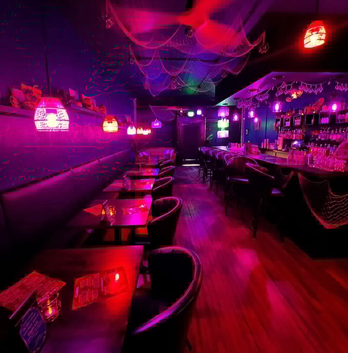 The bar glows like an underwater cave where pirates decided to retire and open a cocktail joint instead.