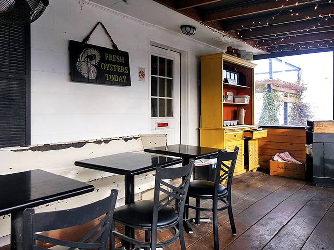 Rustic charm meets waterfront dining with string lights that promise magic after sunset. This covered porch says "stay awhile" in the universal language of comfort.