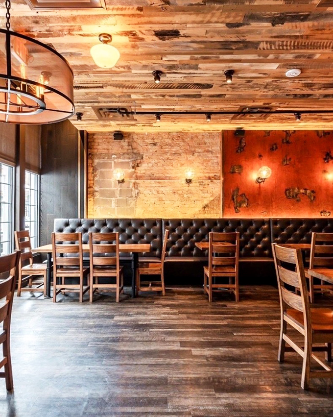 The leather banquettes and weathered wood walls tell stories of meals past, while the warm lighting promises memorable feasts to come.