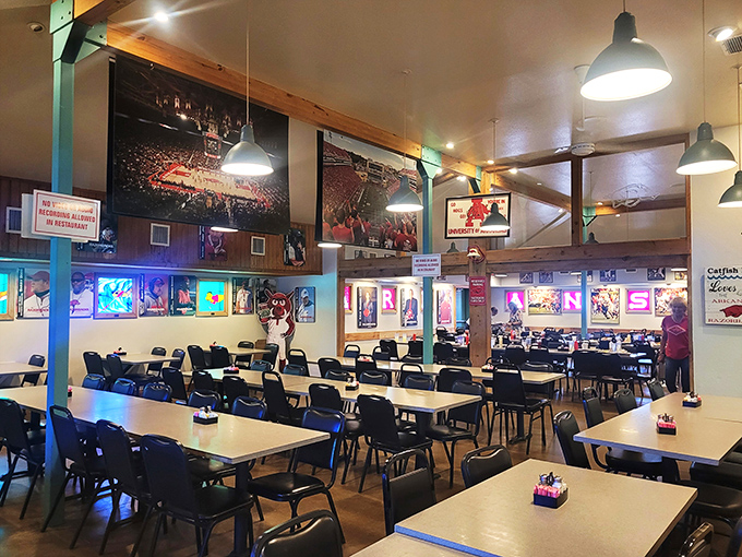 The cathedral-like ceiling and Razorback shrine create a dining space where food and fandom unite in perfect Arkansas harmony.