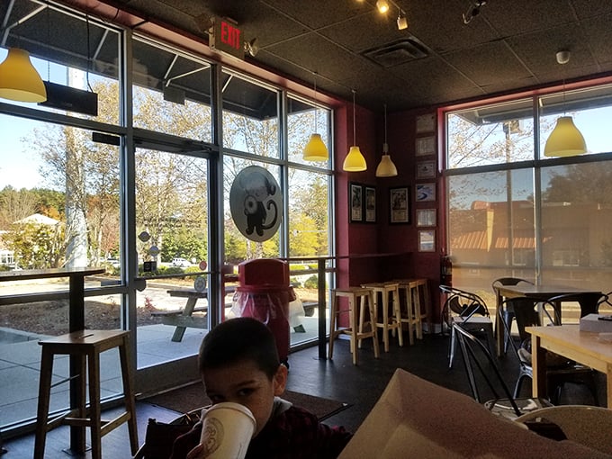 Sunlight streams through large windows, illuminating a space where coffee steam rises and conversations flow as smoothly as the glazes.