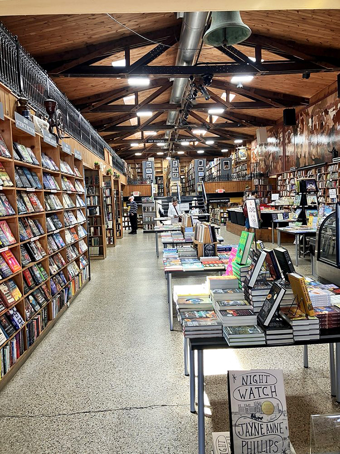 Book browsers in their natural habitat. The main floor's perfectly arranged tables invite literary exploration under the watchful gaze of historic murals.