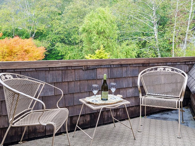 Leather chairs arranged around a rustic coffee table create a gathering space where strangers become friends over evening conversations.